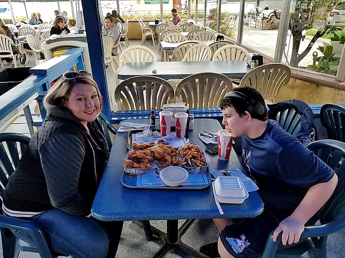 Happy diners experiencing that moment of anticipation before seafood bliss. Their tray holds enough fried goodness to make a cardiologist wince.
