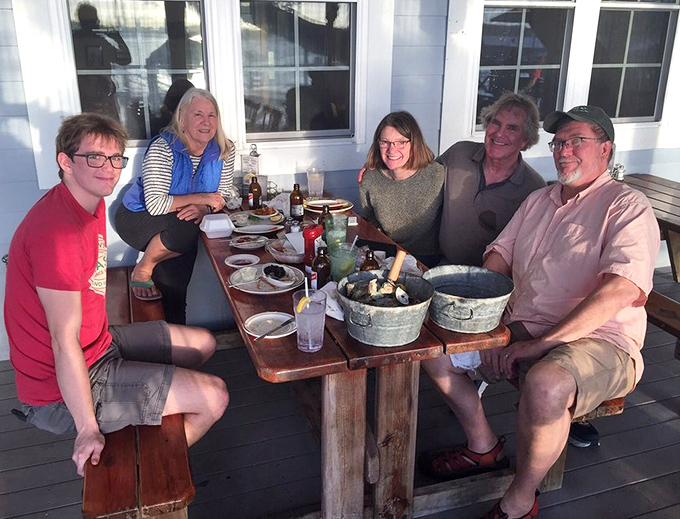 Happy diners soaking up sunshine and seafood on the deck. This is what vacation memories look like before they're even memories.