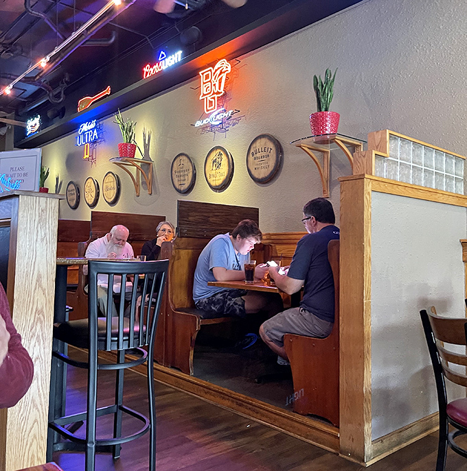 Cozy wooden booths create intimate dining islands beneath barrel accents and neon signs &ndash; the perfect setting for both first dates and hundredth dates.