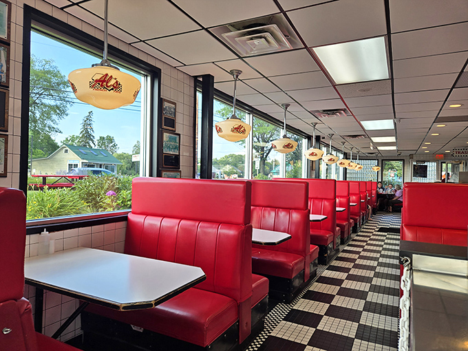 Red vinyl booths lined up like a scene from "Happy Days," where every table has hosted first dates, family celebrations, and the occasional maple syrup-induced sugar crash.