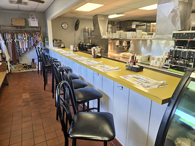 The counter seating offers a front-row view to the kitchen ballet, where placemats showcase local businesses and community connections.