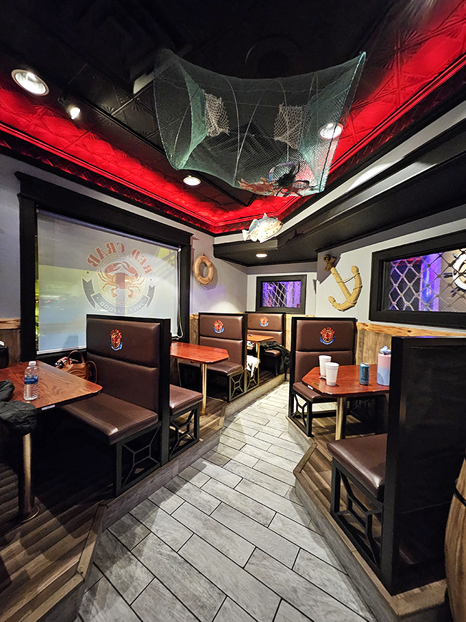 Red ceiling lights, fishing nets, and nautical d&eacute;cor turn this cozy booth area into a little seaside escape&mdash;anchors, lifebuoys, and all&mdash;even if you&rsquo;re nowhere near the coast.