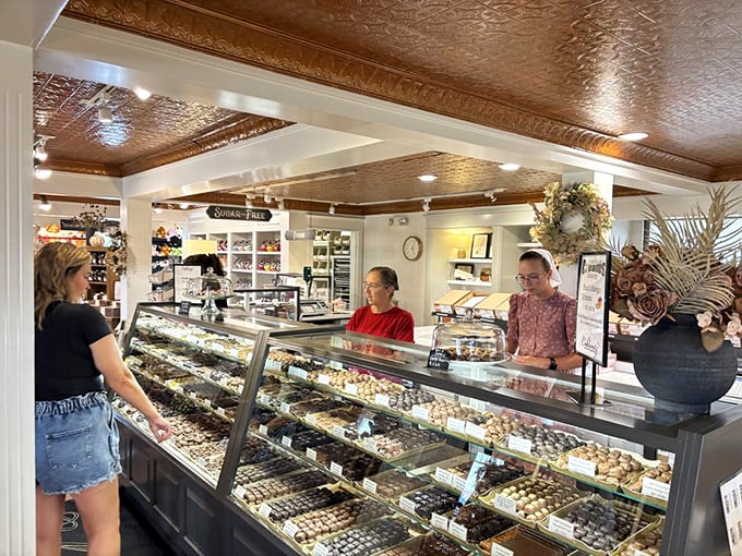 The display case that launches a thousand diet postponements. Row upon row of handcrafted chocolates, each one beckoning with its own sweet siren song.