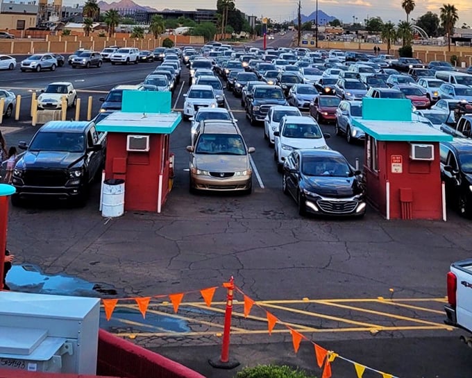 A sea of vehicles arranged with military precision, each one a private viewing pod for cinematic adventures under the stars.