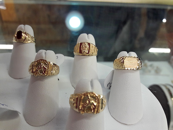 Gold rings gleaming under display lights whisper promises of sophistication that won't require refinancing your mortgage.