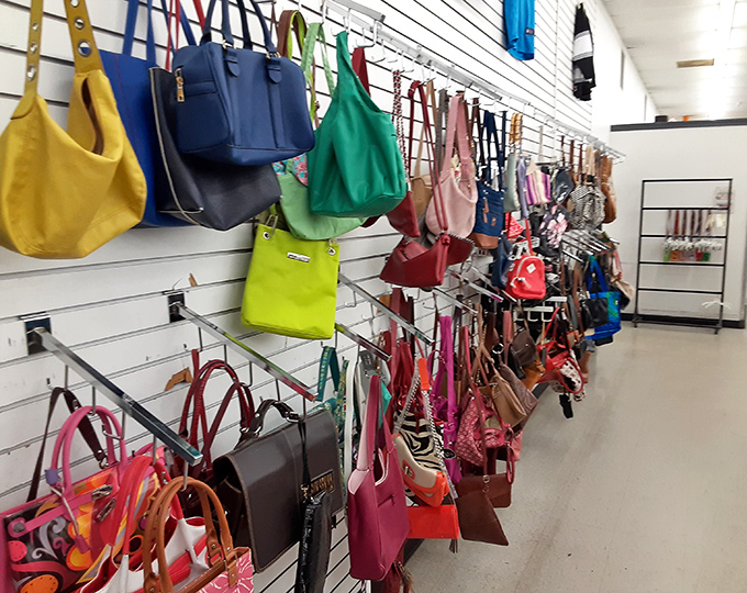 Handbag heaven awaits with a rainbow of purses, totes, and clutches suspended like colorful fruit ripe for the picking.