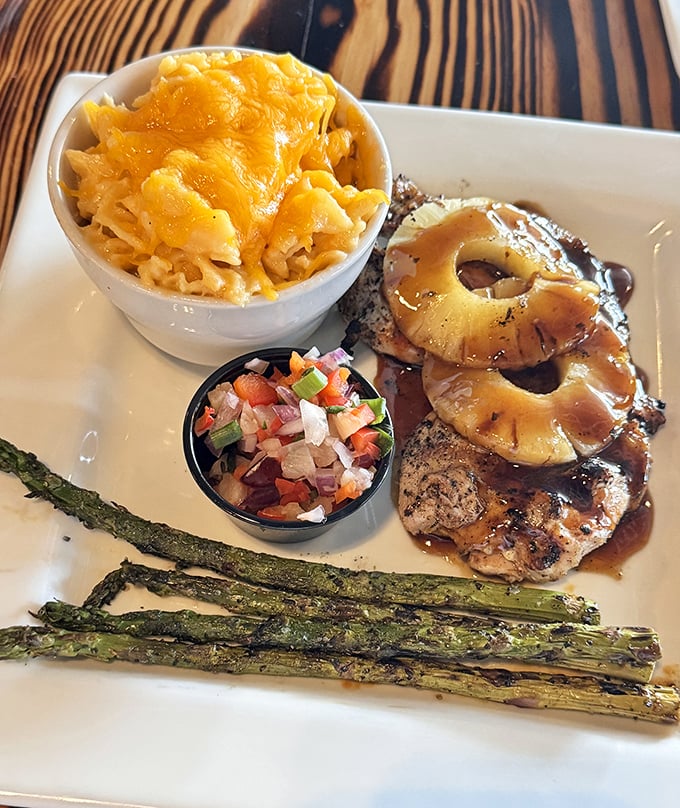 Hawaiian Chicken that's having a beach party with mac and cheese and asparagus. Tropical flavors meet comfort food in a delicious summit.