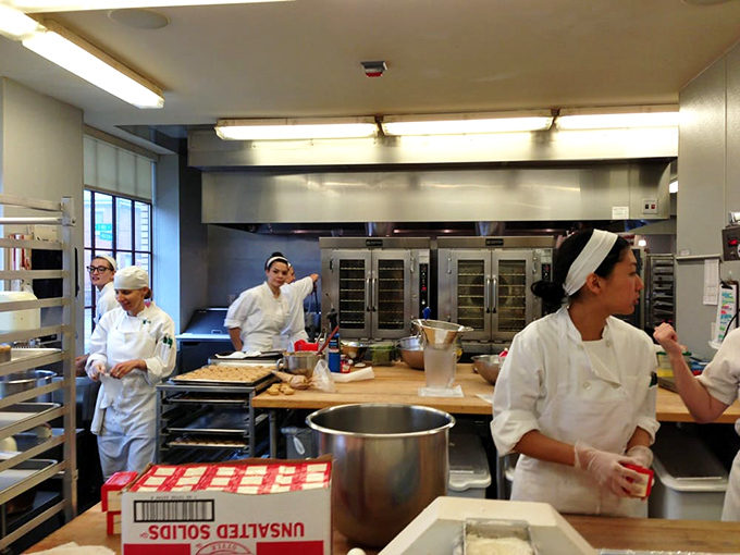 Behind the scenes magic where flour, butter, and skill transform into edible works of art. The white uniforms mean business.