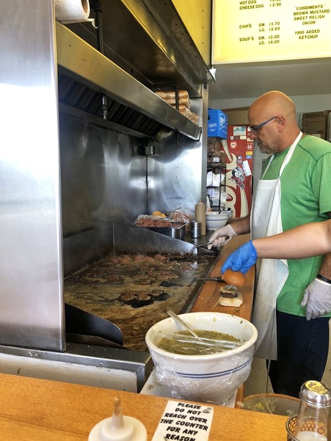 The choreography of the grill master at work. That spatula has probably flipped more burgers than most people have eaten in a lifetime.