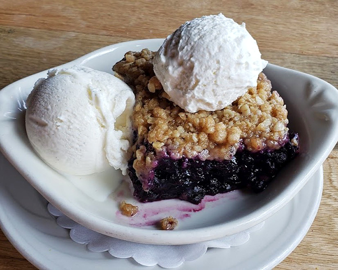 Maine blueberry cobbler topped with vanilla ice cream – where wild berries meet buttery crumble in perfect harmony.