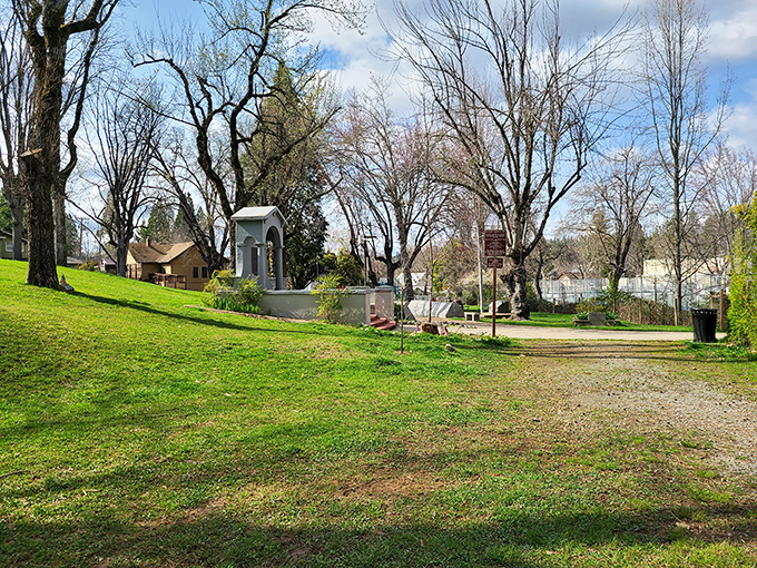 This serene park corner, with its simple monument and dappled shade, offers the kind of quiet reflection spot every small town treasures.