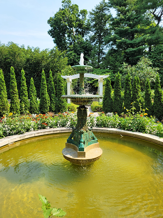 This fountain isn't just showing off&mdash;it's creating the perfect soundtrack for garden strolls while surrounded by a green battalion of perfectly trimmed shrubs.