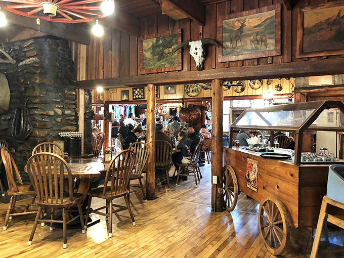 The stone fireplace anchors the dining room where wagon wheel chandeliers and Western artwork transport you to simpler times&mdash;no DeLorean required.