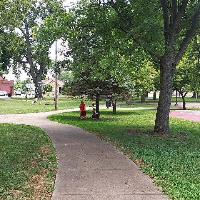 Poland Park's winding paths invite leisurely strolls beneath shade trees, where generations gather and the only notification you'll receive is from a chattering squirrel.