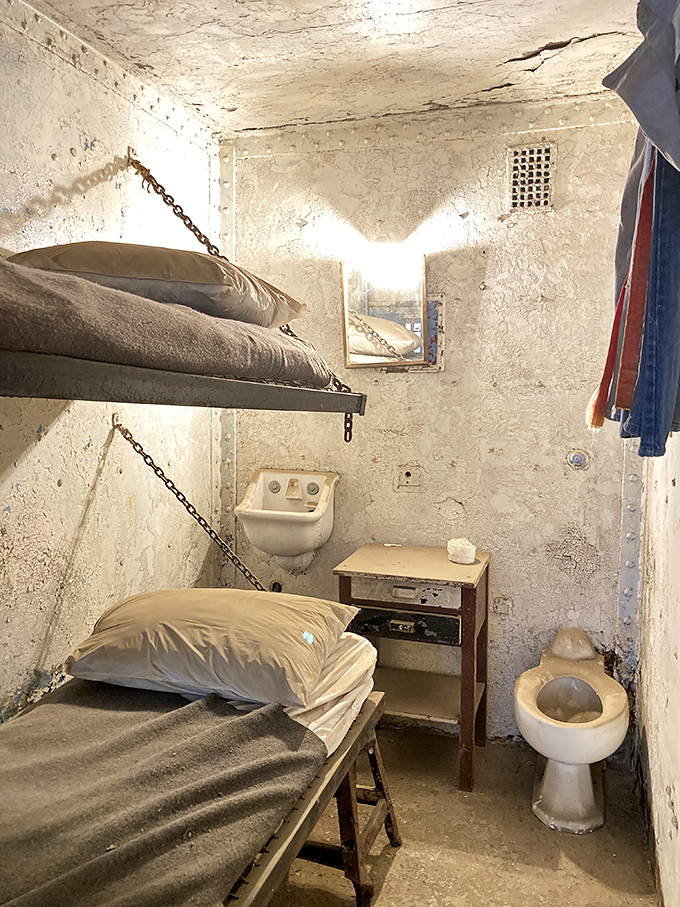 Home sweet cell&mdash;complete with bunk beds chained to walls and zero privacy. The toilet placement suggests interior decorating wasn't high on the priority list.