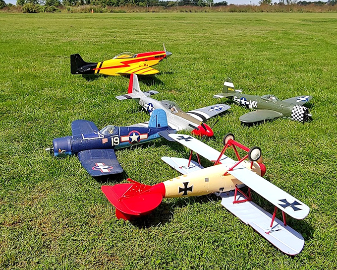 A squadron of model aircraft awaits deployment&mdash;each tiny plane representing hours of meticulous craftsmanship and the joy of controlled chaos.