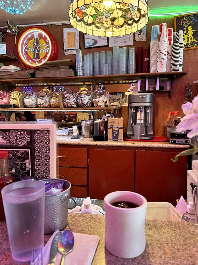 Behind that counter, culinary magic happens 24/7, with Tiffany lamps casting their warm glow over the organized chaos.