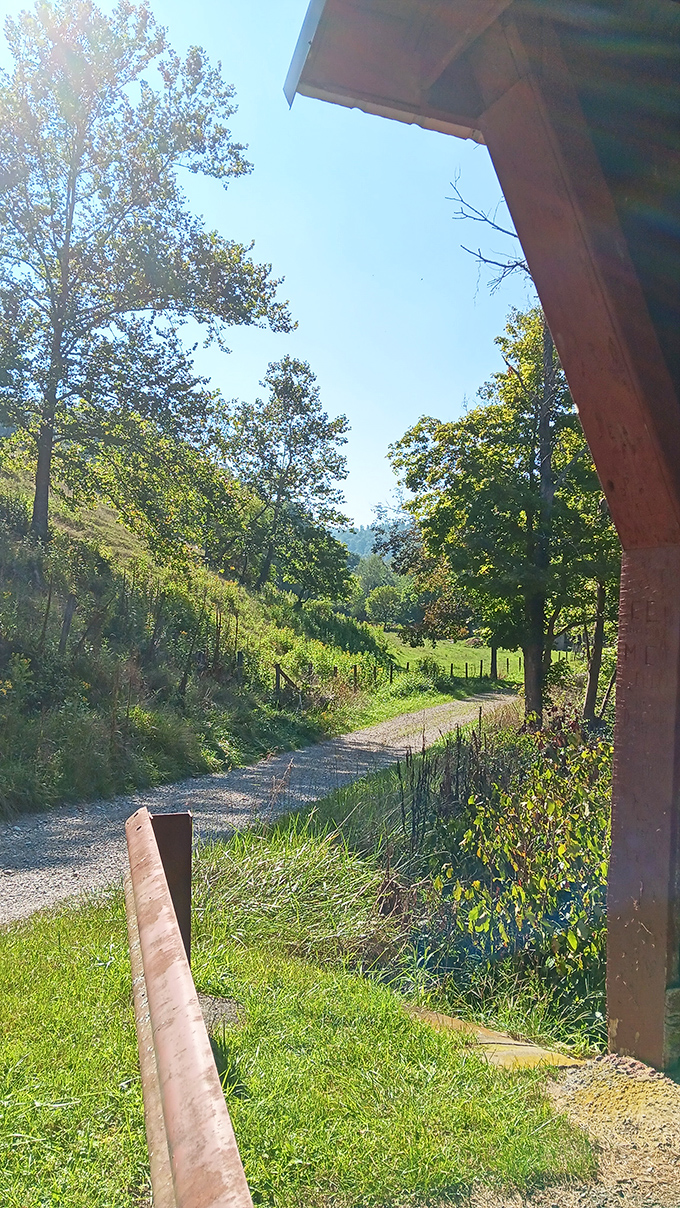 The path beside the bridge invites exploration, leading visitors into the kind of countryside that inspired American folk songs.