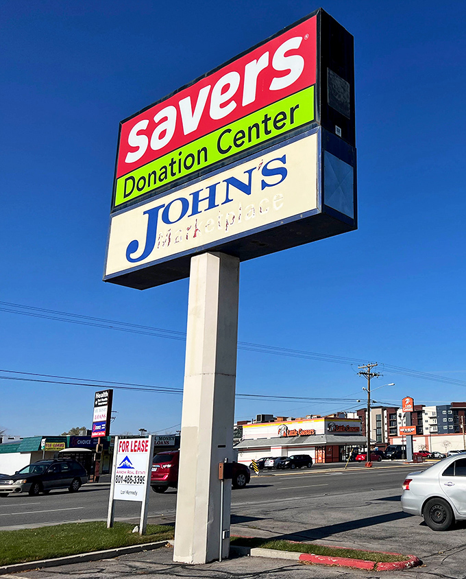 The roadside sign stands tall against Utah's blue sky. John's Real Estate might share the signage, but Savers is the true neighborhood landmark. 