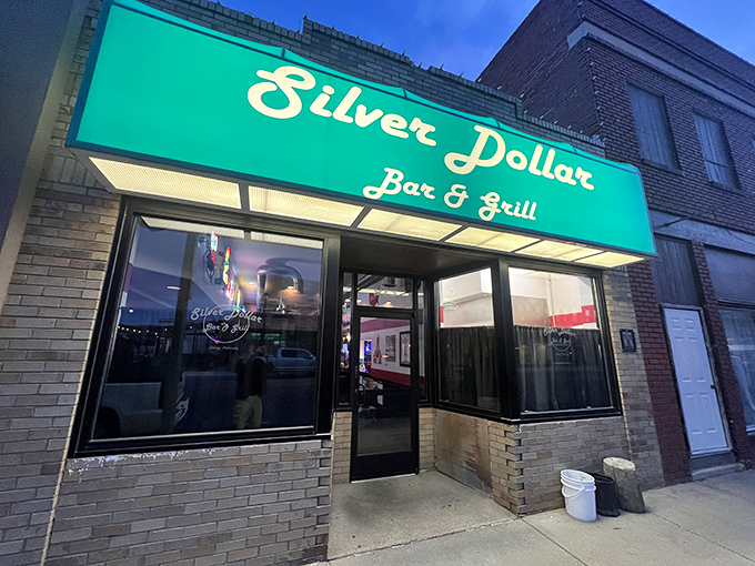 The Silver Dollar Bar & Grill's neon glow beckons travelers and locals alike, promising cold drinks, hot food, and conversations that don't involve asking about Wi-Fi passwords.