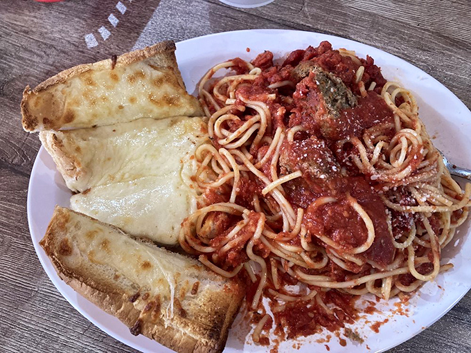 Spaghetti that doesn't need a passport to transport you to Italy. The garlic bread stands ready to soak up every last drop of that magnificent sauce.
