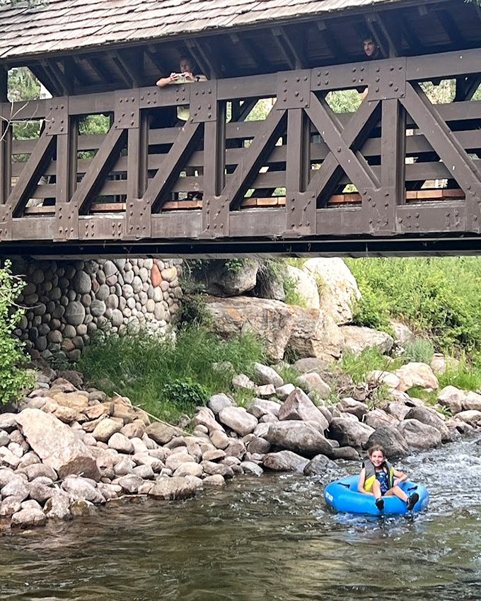 Nothing says "I'm embracing mountain life" quite like floating under a historic bridge while the tourists above envy your cool blue tube.