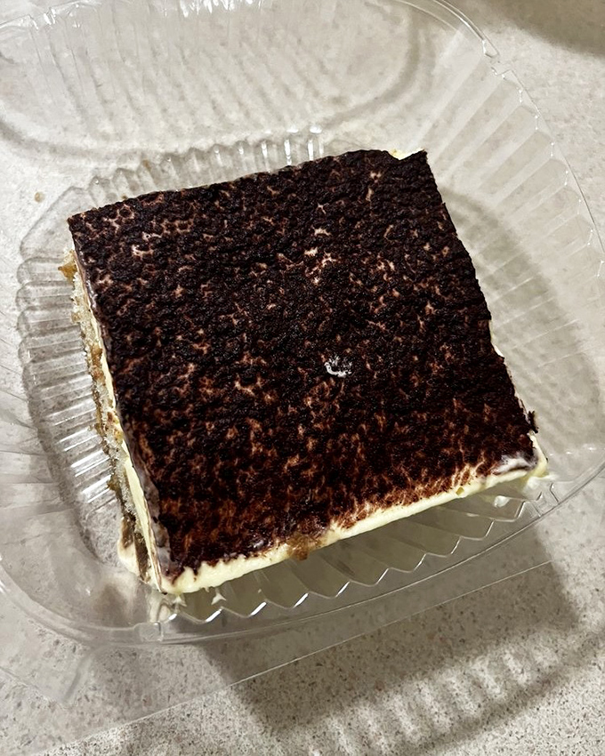 This tiramisu square isn't messing around. The cocoa dusting on top is like a chocolate snowfall on a creamy mountain of mascarpone bliss.