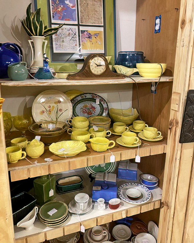 Sunny yellow dishware brightens these shelves like captured sunshine &ndash; mid-century pottery that once graced Sunday dinner tables now waits for new family gatherings.