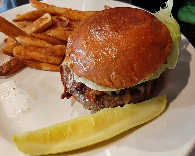 This isn't just a burger&mdash;it's architecture. The perfectly toasted bun supports its towering contents while that pickle slice waits patiently for its moment.