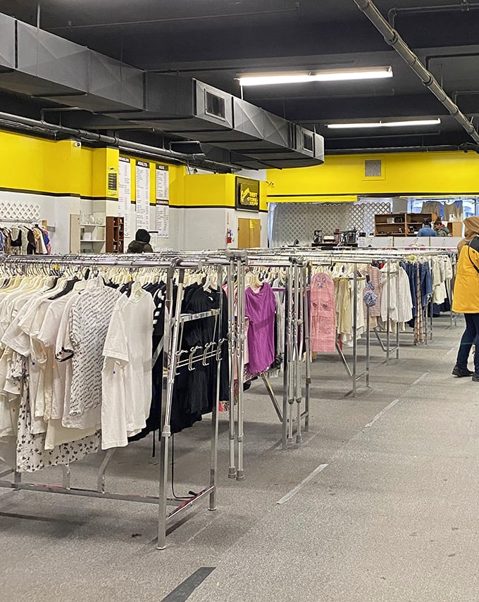 Yellow walls brighten the women's clothing section, where racks of carefully organized garments create a rainbow of second-hand style options.
