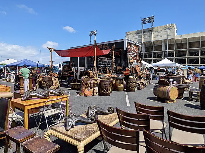 Furniture with character crowds the stadium parking lot. Those wooden barrels probably held something interesting long before becoming decorative conversation pieces.