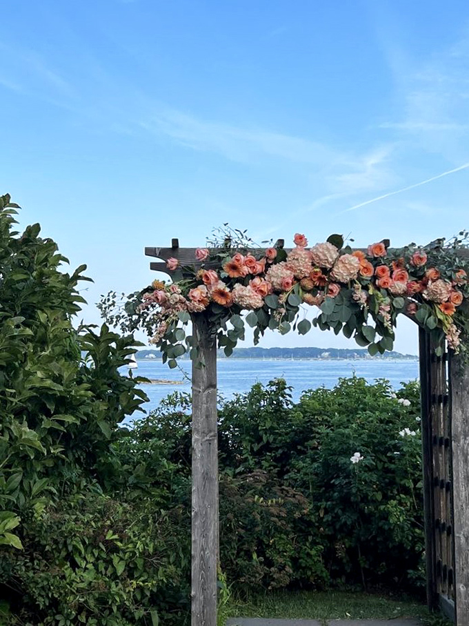Nature and architecture collaborate on this floral gateway, framing the ocean view like a living postcard from another century.