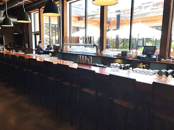 The bar stretches like a runway for craft beverages, where house-brewed beers and artisanal cocktails await their moment in the spotlight.