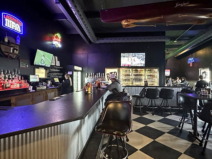 The bar area offers a classic steakhouse atmosphere with checkered floors and neon signs. Where locals and visitors alike find common ground.