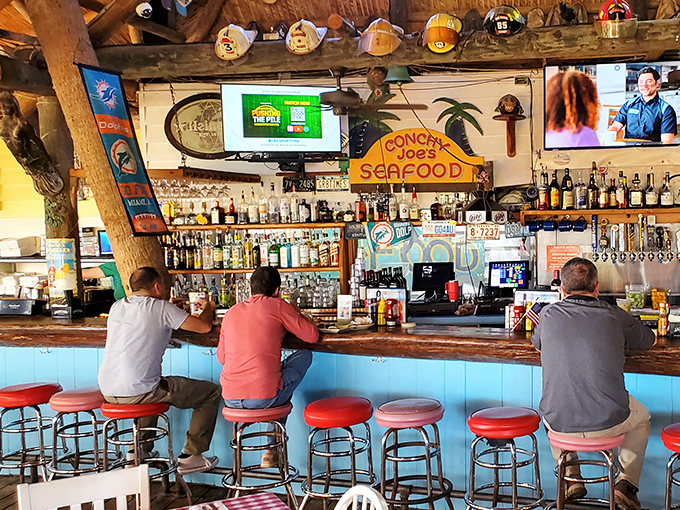 The bar where Jimmy Buffett lyrics come to life. Notice the fishing hats and palm tree decor &ndash; they're not trying to be coastal, they just are.