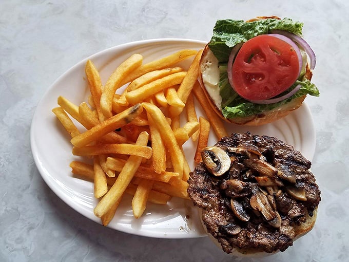 A burger that means business, topped with saut&eacute;ed mushrooms and paired with fries that achieve the perfect golden-to-crisp ratio.