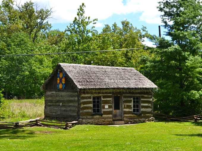 This log cabin sits in quiet dignity, its hand-hewn walls and quilt block decoration representing frontier ingenuity at its most authentic.