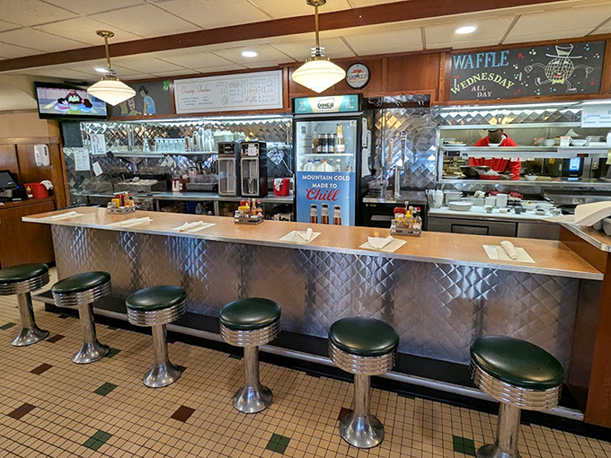 Where the magic happens—chrome, tile, and the promise of comfort food. Those green stools have witnessed countless coffee refills and life decisions.
