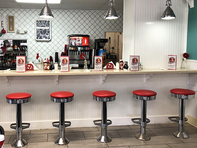 Classic diner counter seating with fire-engine red stools—where solo diners become part of the breakfast brotherhood without saying a word.