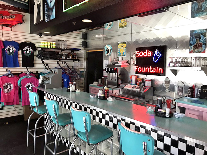 The soda fountain counter promises fizzy delights while the neon signs cast that perfect glow that makes everyone look like they're in a movie.