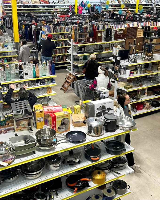 The thrift store ecosystem in action&mdash;treasure hunters scanning shelves while cookware waits patiently for its next kitchen adventure.