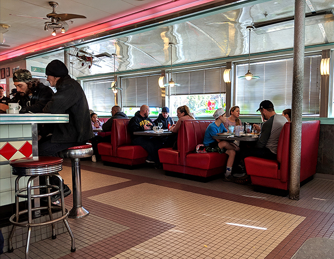 Where strangers become neighbors over coffee and conversation in those unmistakable red booths that have witnessed countless life stories.