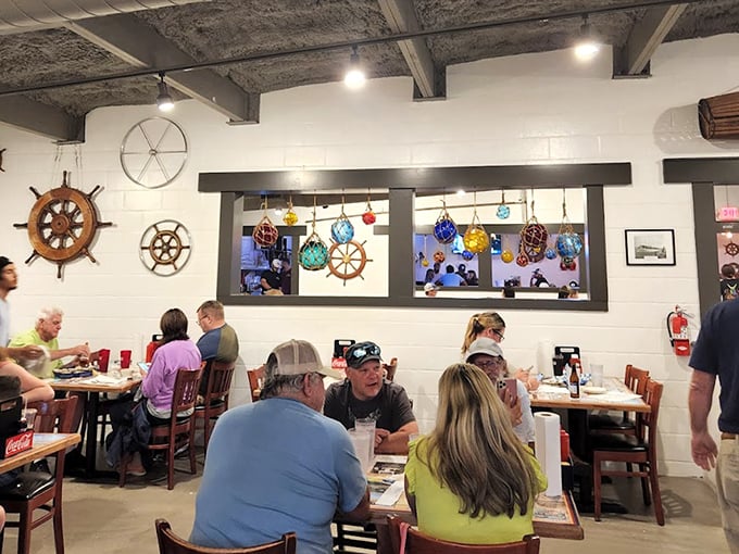 The dining room where strangers become friends over shared recommendations. Ship wheels and colorful glass floats create the maritime museum vibe every seafood joint aspires to.