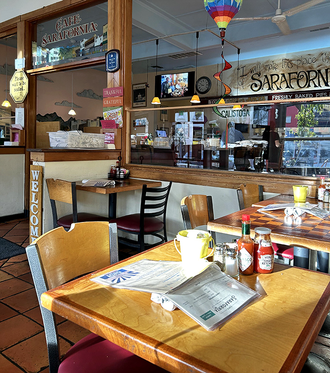 Wooden tables bathed in natural light, colorful wall art, and the promise of "WELCOME" signs create the perfect setting for morning conversations.