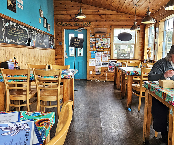 Wooden tables, colorful tablecloths, and that turquoise door promising adventure. The kind of place where strangers become friends over shared condiments.