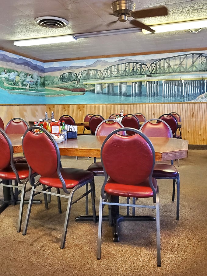 The mural depicting Parker Dam and bridge transforms a simple dining room into a celebration of local identity, while those red chairs invite you to stay awhile.