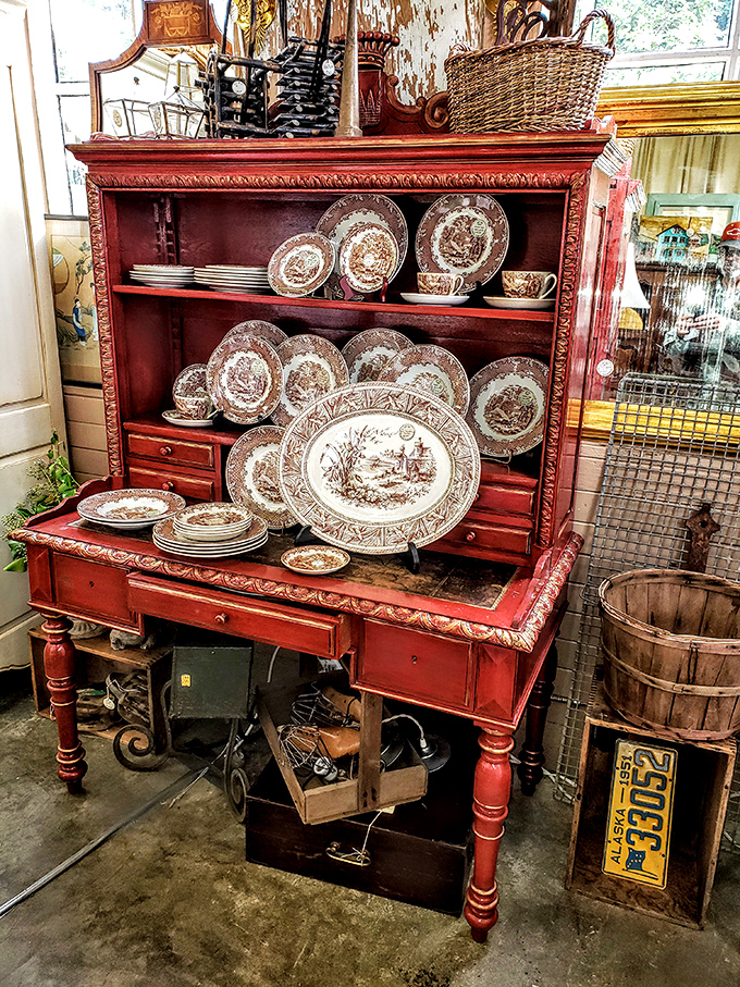 A red hutch displays dinnerware patterns your mother coveted, now available without the matching family drama attached.