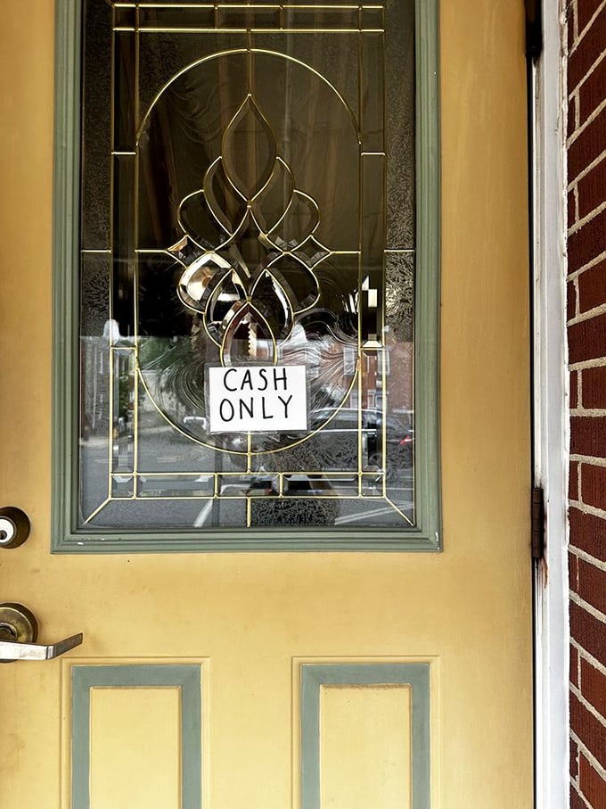 The "CASH ONLY" sign on the elegant glass door &ndash; a charming reminder that some traditions are worth keeping, like carrying actual money.