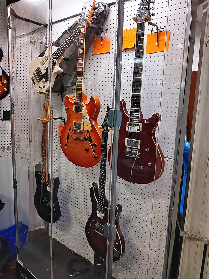 Silent until strummed, these guitars hang like sleeping rock stars waiting for their next gig in someone's living room.