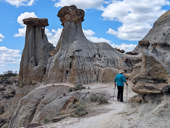 Dwarfed by nature's skyscrapers, a hiker explores the trail beneath towering hoodoos that seem to defy both gravity and imagination.